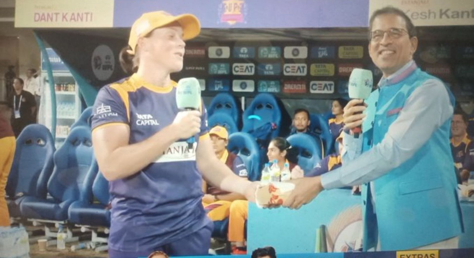 [Picture] WPL 2023 presenter Harsha Bhogle gifts Grace Harris a burger ...